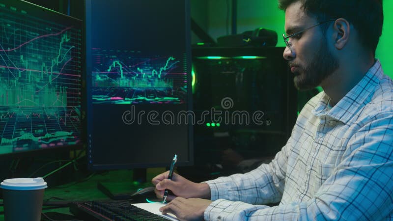Indian Arabian Man Writing Notes Notebook Working With Pc Computer Trader Programmer Coder