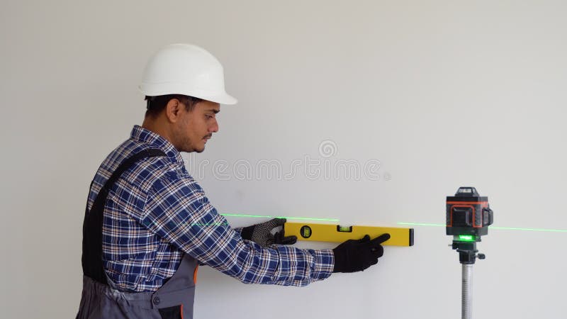 Indian Asian Worker in Measuring Wall with Laser Leveler at ...