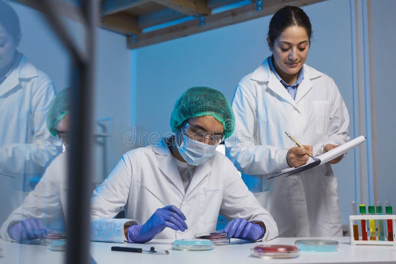 Indian Assistant Making Notes about Changes of Microorganism Stock ...