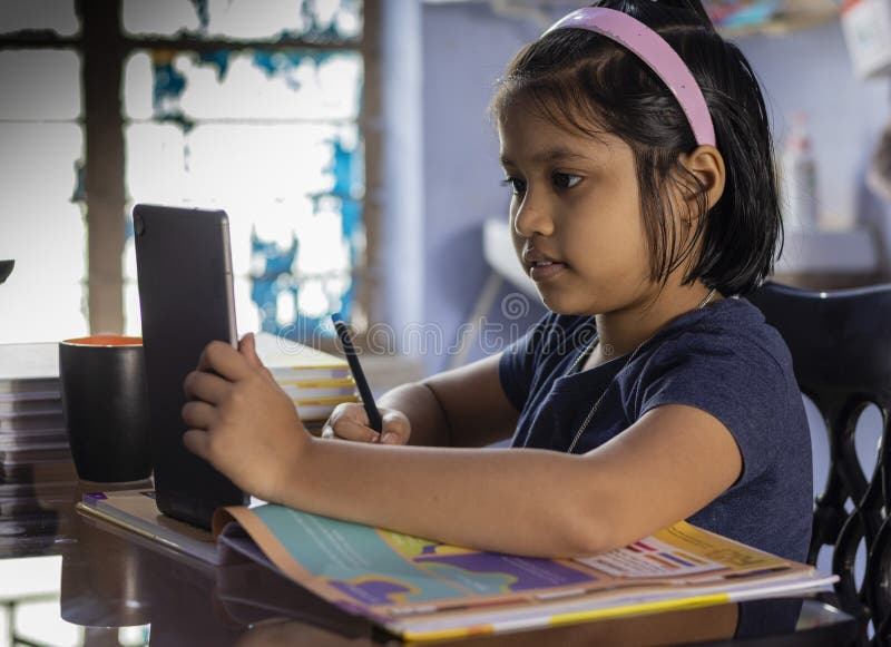 An Indian Cute Girl Child Studying at Home with Tablet Stock Photo ...