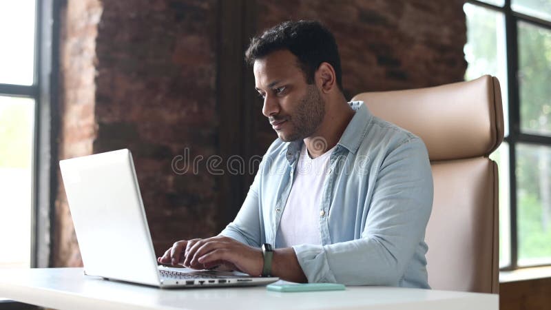 Indian Developer Guy is Working with a Laptop Sitting at the Desk ...