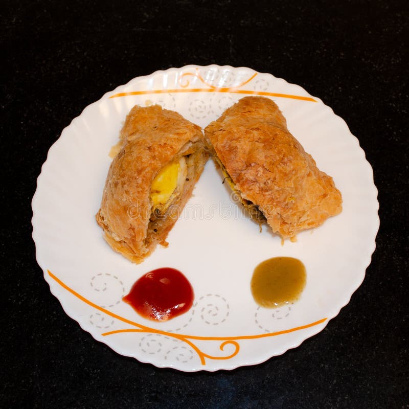 Indian Egg Puff Served with Tomato and Chilli Sauce in a White Ceramic ...