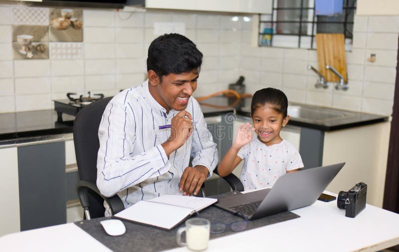 An Indian Father and Daughter Using Laptop Computer in the Kitchen at ...