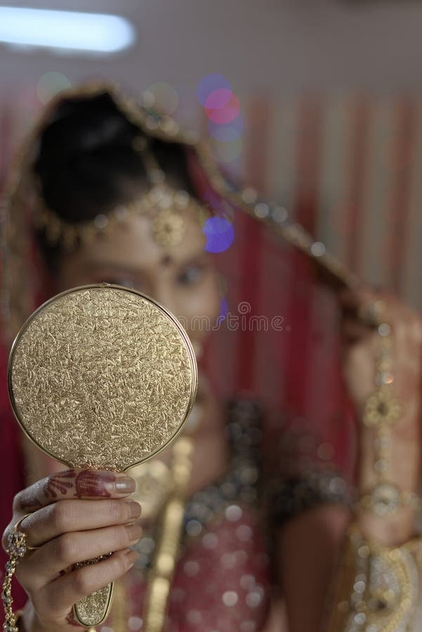 Indian Hindu Bride with Jewelry Looking in Mirror. Stock Image - Image ...
