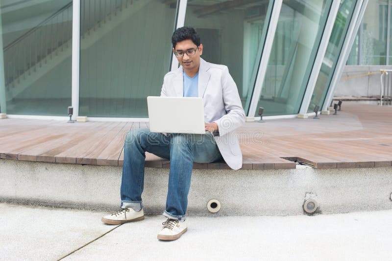 Indian male using laptop stock image. Image of modern - 69027379