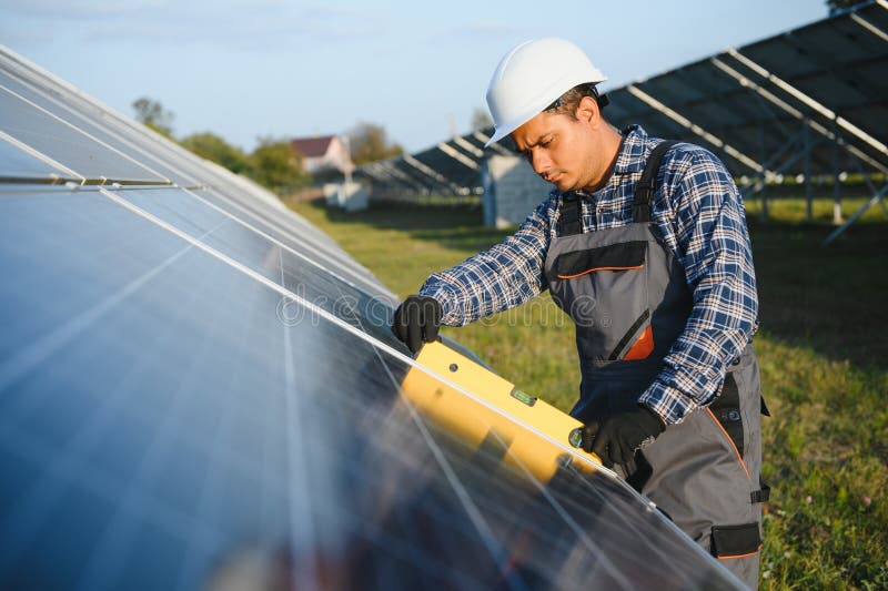 An Indian Male Worker is Working on Installing Solar Panels in a Field ...