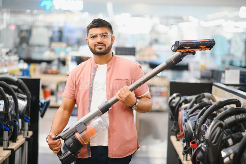 An Indian Man is Choosing a New Vacuum Cleaner in an Electronics Store ...