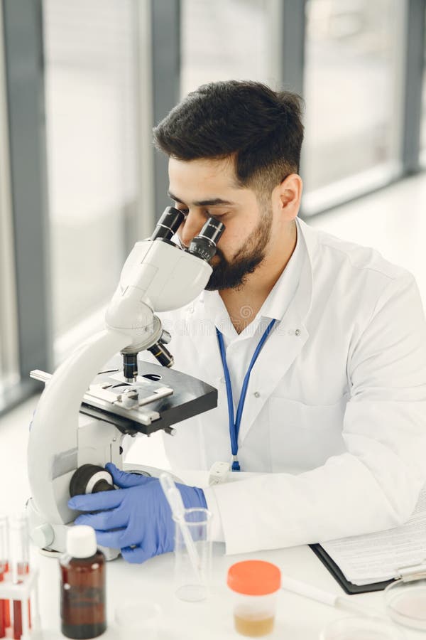 A Laboratory Scientist is Examining Blue Solution in a Bottle Stock ...