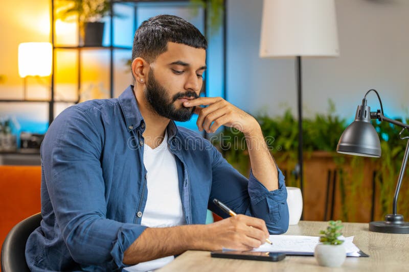 Indian Man Freelancer Working with Documents from Home Office Analyzing ...