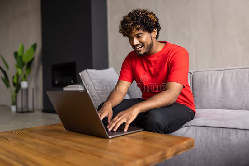 Indian Man Sitting on a Couch Working on a Laptop Stock Image - Image ...