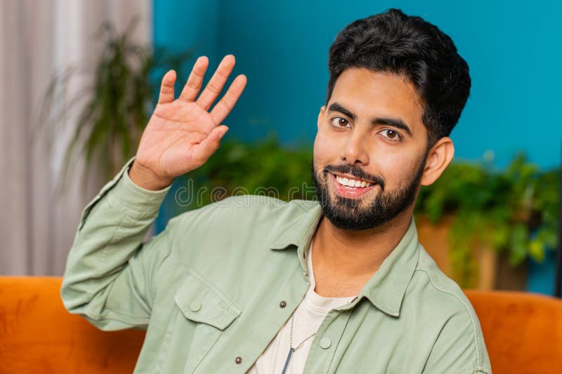 Indian Man Smiling Friendly at Camera, Waving Hands Gesturing Hello, Hi ... Indian Man Smiling Friendly at Camera, Waving Hands Gesturing Hello, Hi ...