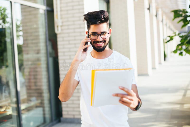 Indian Young Man Talking on the Phone and Holding Notebook with Mark in ...