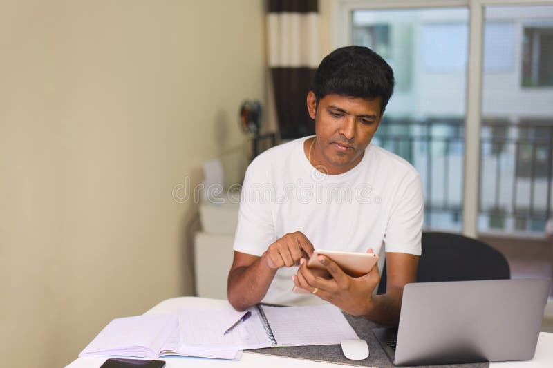 Indian Man Using Digital Tablet and Laptop Computer in the Living Room ...