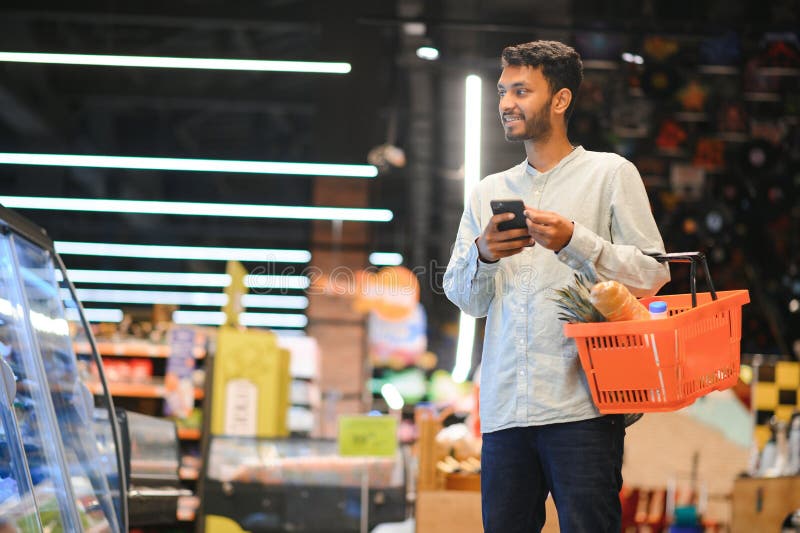 Indian Man Using Smartphone at Grocery Shop. Stock Photo - Image of ...