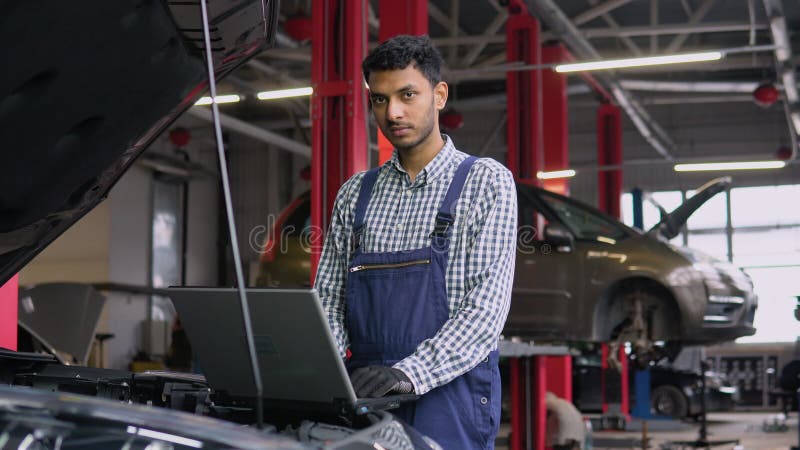Indian Man at the Workshop in Uniform Using Laptop for His Job for ...