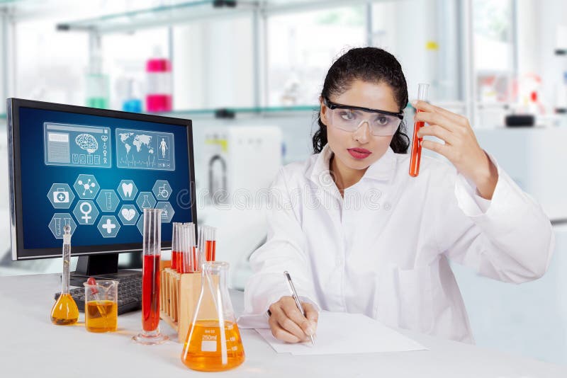 Indian Scientist Working with a Computer and Doing Chemical Test Stock ...