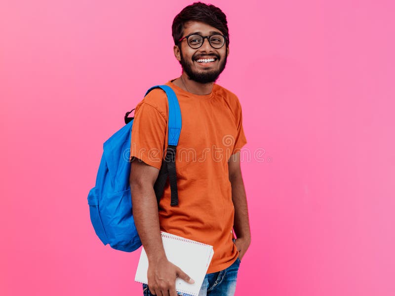 Indian Student with Blue Backpack, Glasses and Notebook Posing on Pink ...