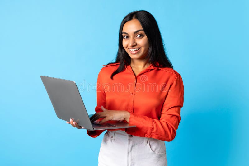 Indian Woman Using Laptop Computer Typing on Blue Studio Background ...