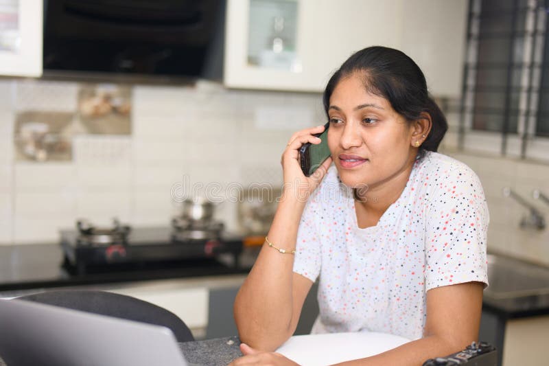 Indian Woman Working at Home with Laptop and Talking on the Phone Stock ...