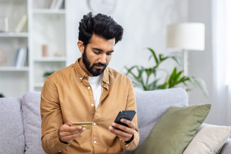 Indian Young Man Sitting on Sofa at Home and Using Mobile Phone and ...