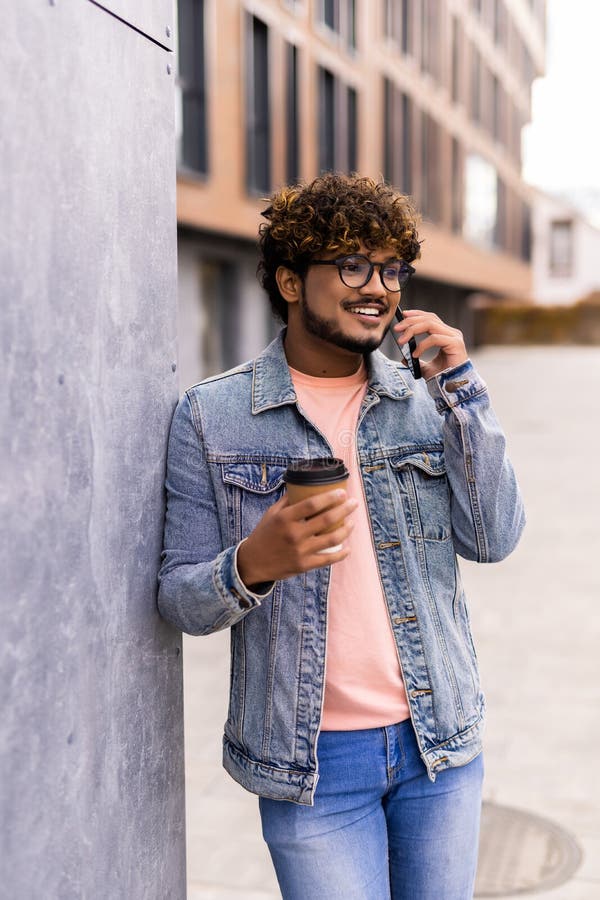 Indian Young Man Use Phone Drinking Phone while Walking on the Street ...