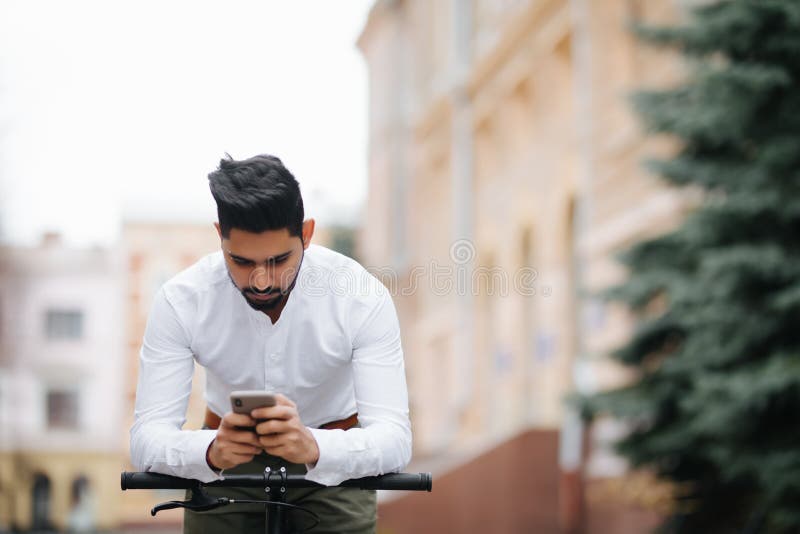 Indian Young Man Using Mobile Phone and Fixed Gear Bicycle in the ...