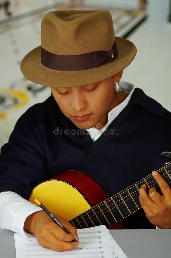 Indigenous Young Man Writing Notes To Music with Guitar, Concept of ...