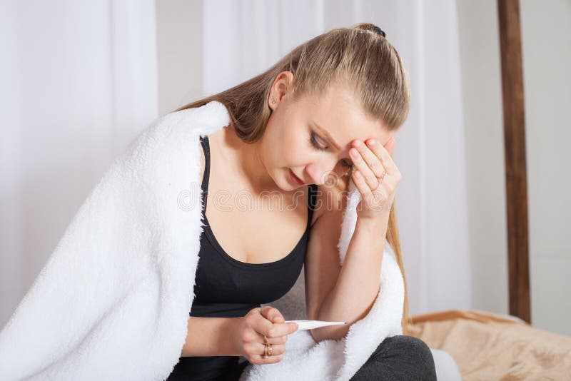 Indisposed Woman Feeling Her Temperature while Resting on the Sofa ...