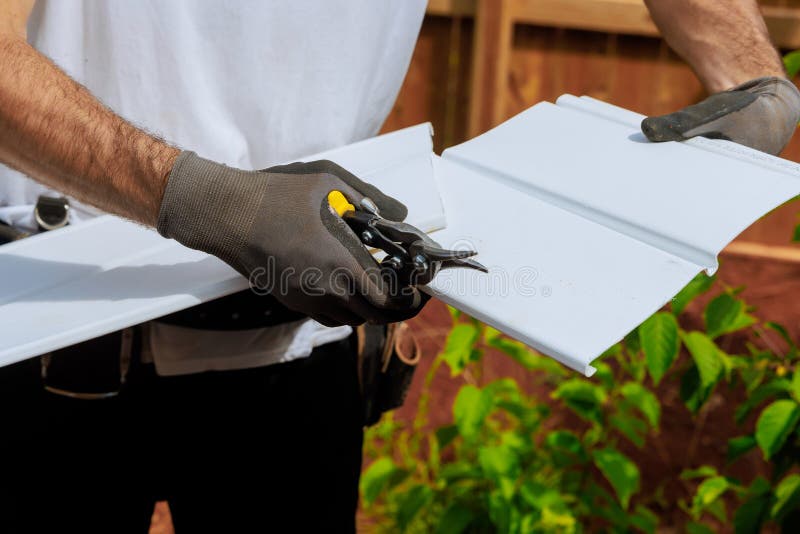 An Individual Cuts Plastic Vinyl Siding To Size before it is Installed ...