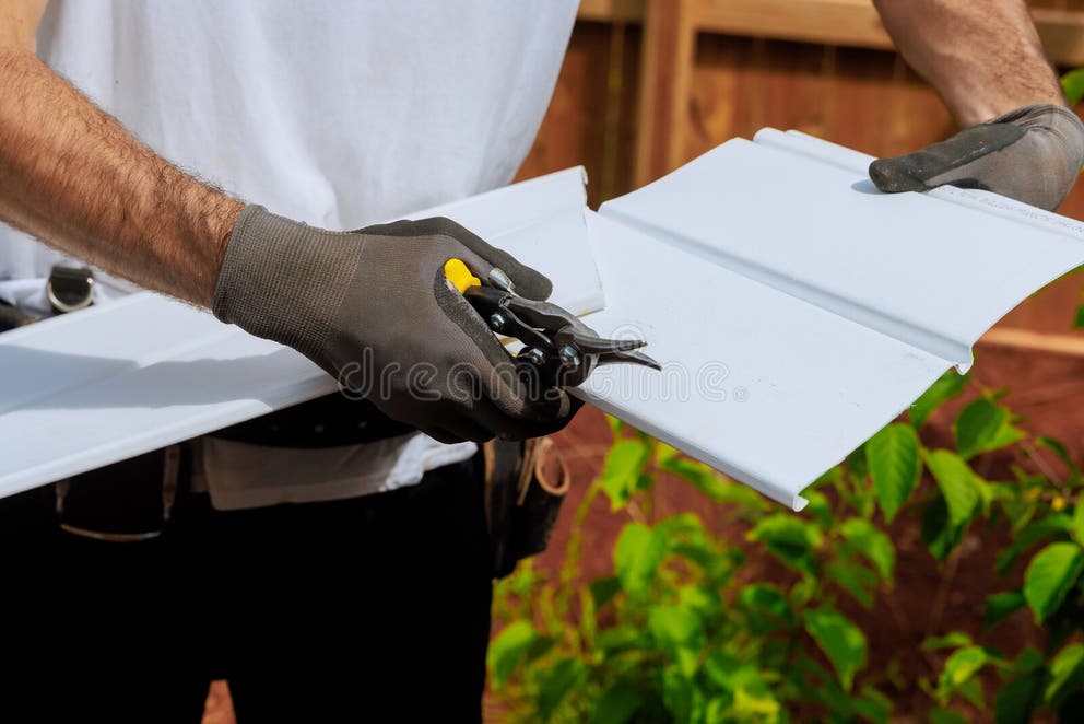 An Individual Cuts Plastic Vinyl Siding To Size before it is Installed ...