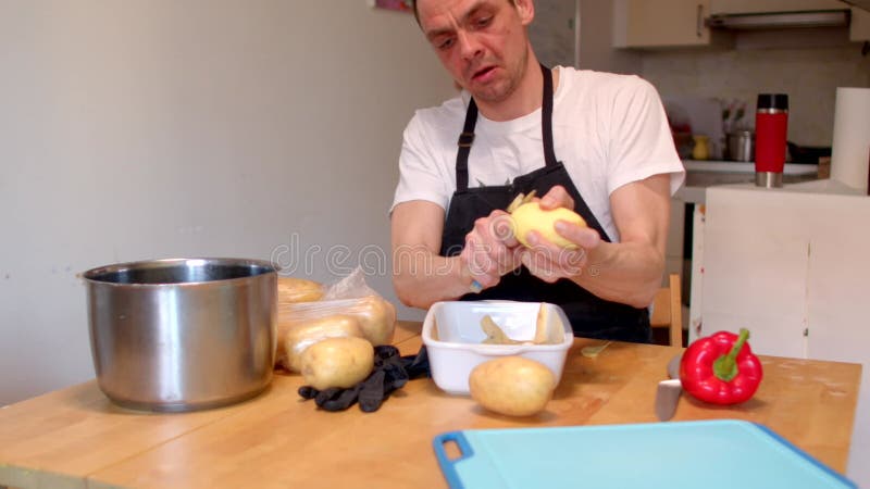 A Person is Peeling Potatoes in the Kitchen Along with a Red Pepper and ...