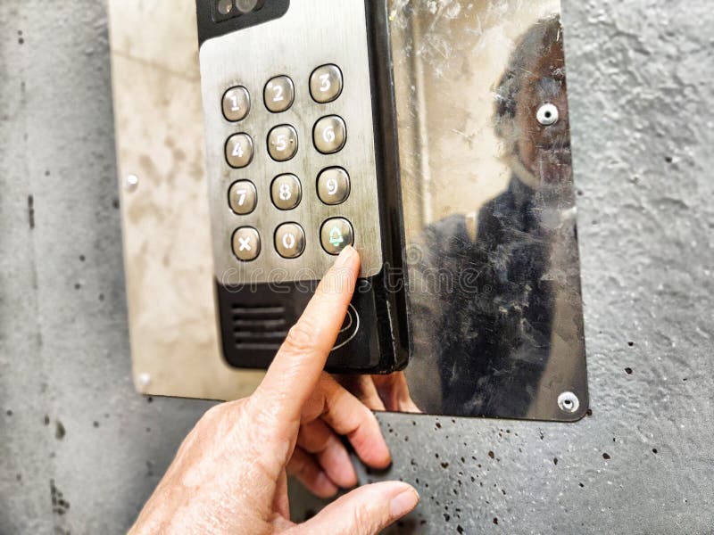 Individual Pressing the Intercom Button Outside an Entrance in an Urban ...