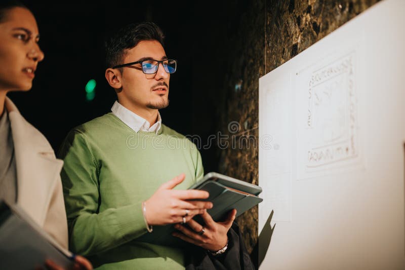 Individuals Analyze Art Exhibits Inside a Dimly Lit Museum Setting ...