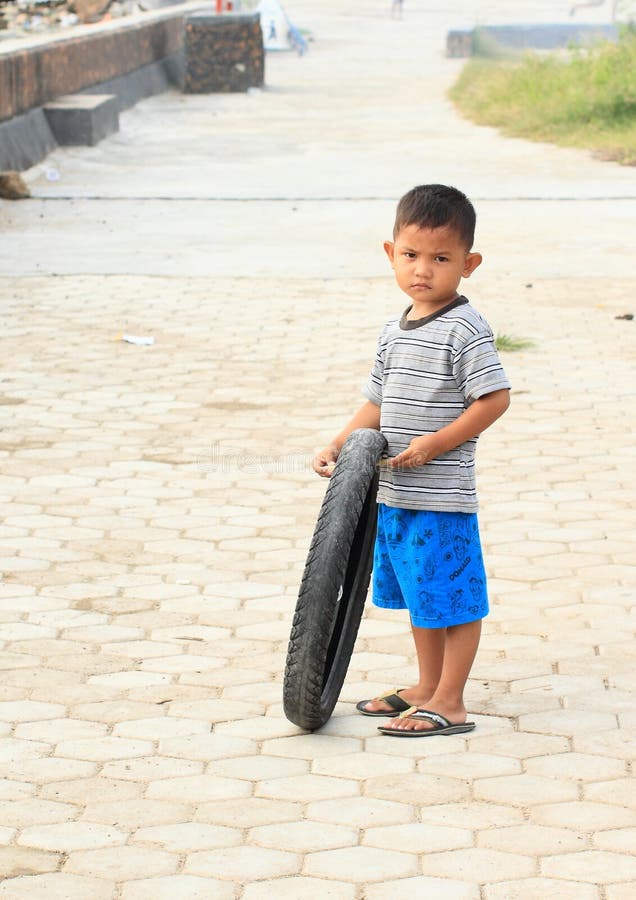 Indonesian boy with tire editorial photo. Image of playing - 38240181
