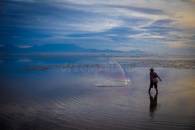 Indonesian Fisherman Throwing a Net Stock Photo - Image of light ...
