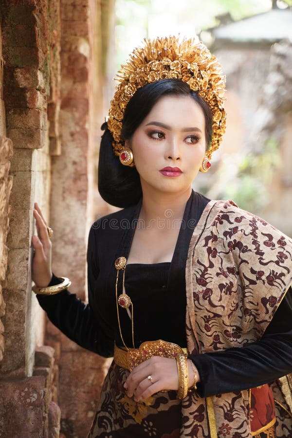 Indonesian Girl Wearing Balinese Kebaya Next To A Relief Wall Stock