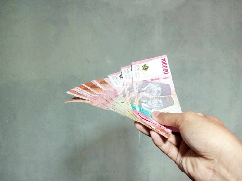 Indonesian Money Rp. 100,000 Being Held by a Man& X27;s Hand Stock ...