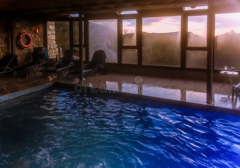 Indoor Pool with Jacuzzi and Views of the Mountains at Sunset through ...