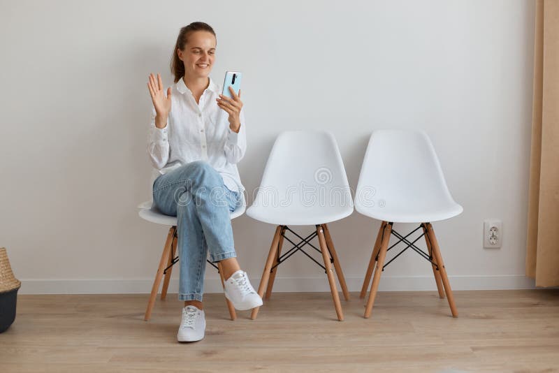 Indoor Shot Of Attractive Dark Haired Woman Wearing White Shirt And