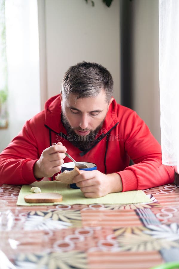 Man in Red Eats Soup at a Patterned Table, Enhancing a Cozy, Focused ...