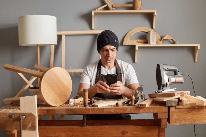 Indoor Shot of Serious Worker or Builder Wearing Cap and Apron Using ...