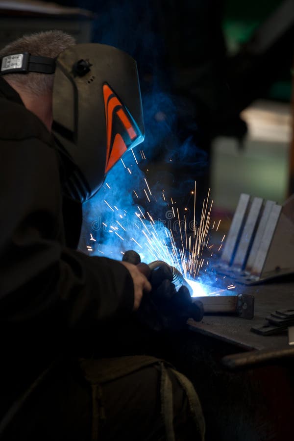 Worker in Mask, in the Process of Welding Metal with Bright Light ...