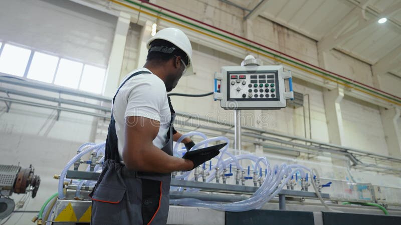 Industrial Black Worker Programmer Checking the Production Line with ...
