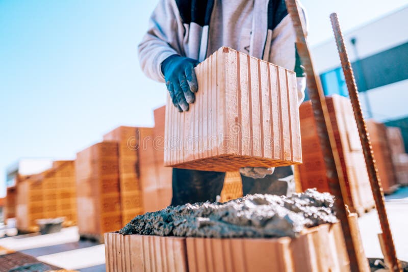 Industrial Bricklayer Installing Bricks on Construction Site Stock ...
