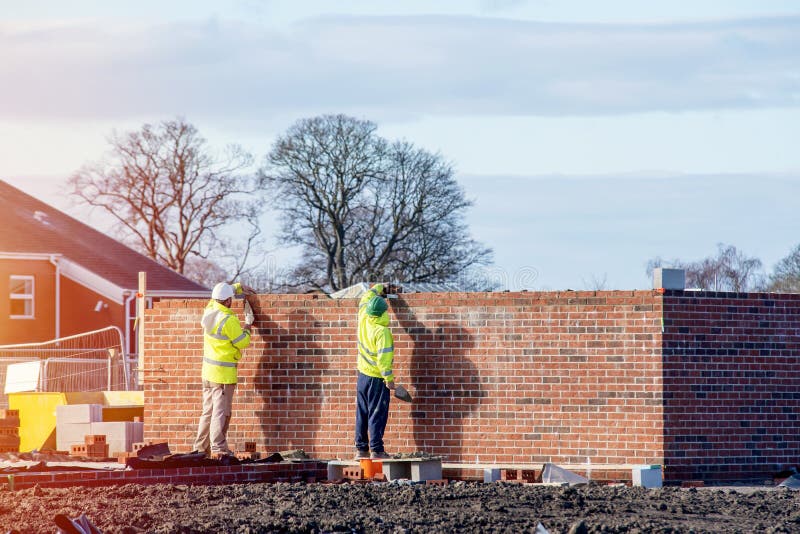 Industrial Bricklayer Laying Bricks on Cement Mix on Construction Site ...