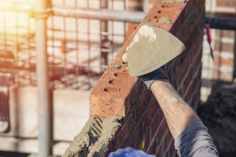 Industrial Bricklayer Laying Bricks on Cement Mix on Construction Site ...