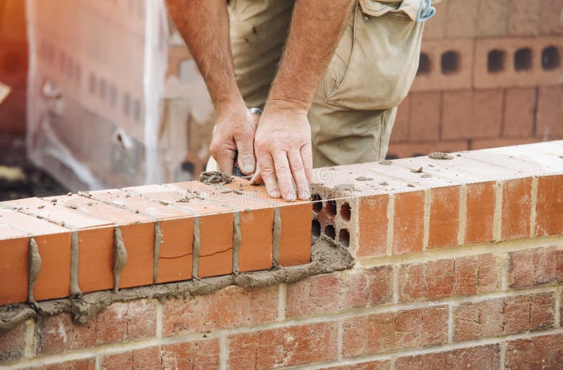 Industrial Bricklayer Laying Bricks on Cement Mix on Construction Site ...