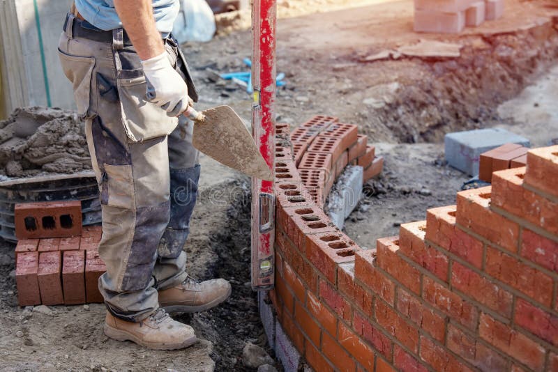 Industrial Bricklayer Laying Bricks on Cement Mix on Construction Site ...