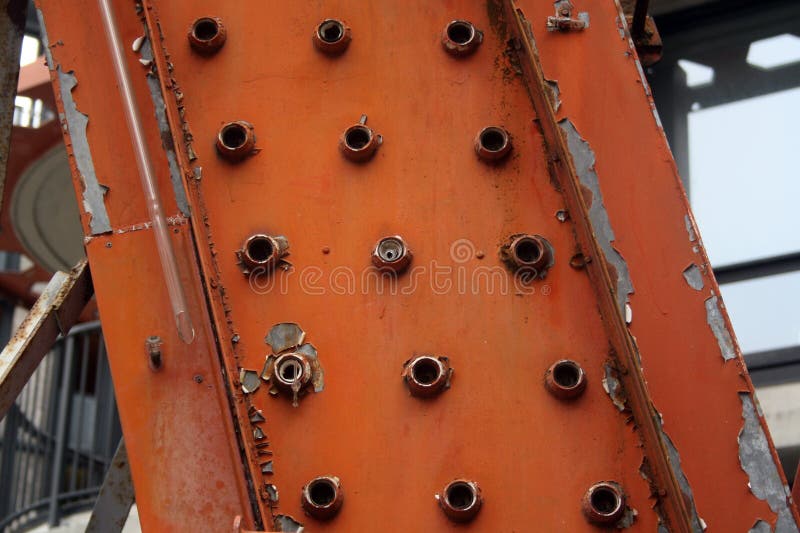 An Industrial Structure with Holes on the Side of it and a Clock Above ...