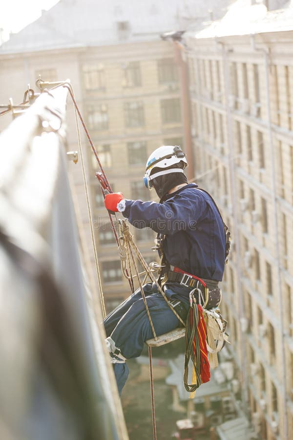 Industrial Climber Lowering from Roof of Building Stock Image - Image ...